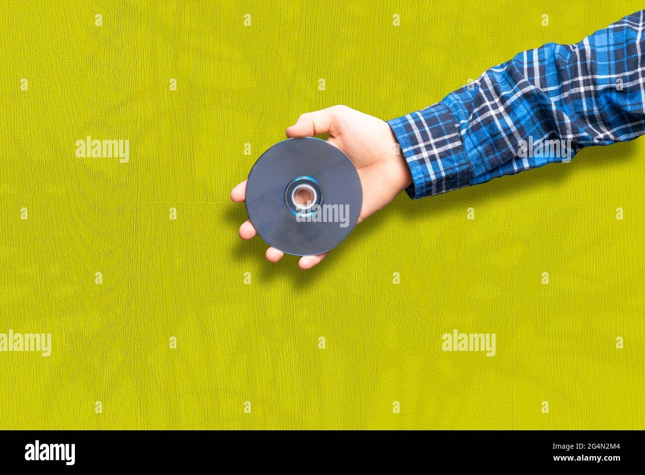 isolated hand holding a vintage cd or dvd disc on color background ...