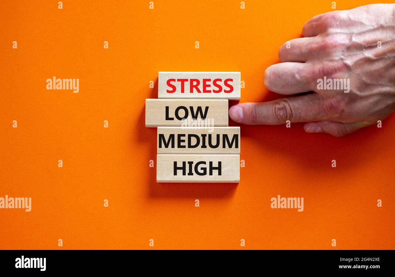 Low Or High Stress Level Symbol Businessman Chooses The Wooden Block low-or-high-stress-level-symbol-businessman-chooses-the-wooden-block