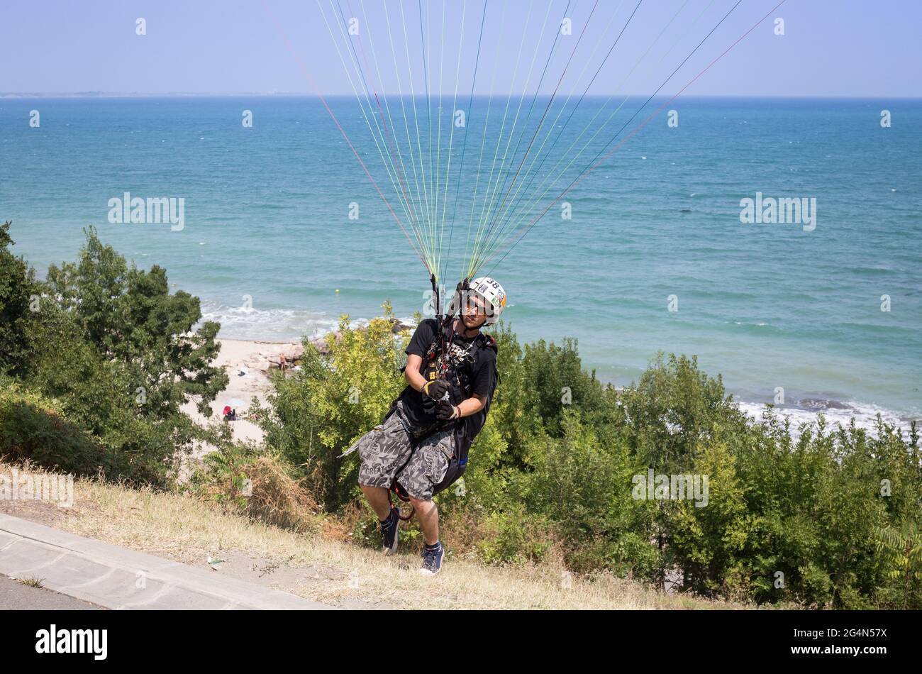 Paraglider pilot in the process of taking off on the beach Stock Photo ...