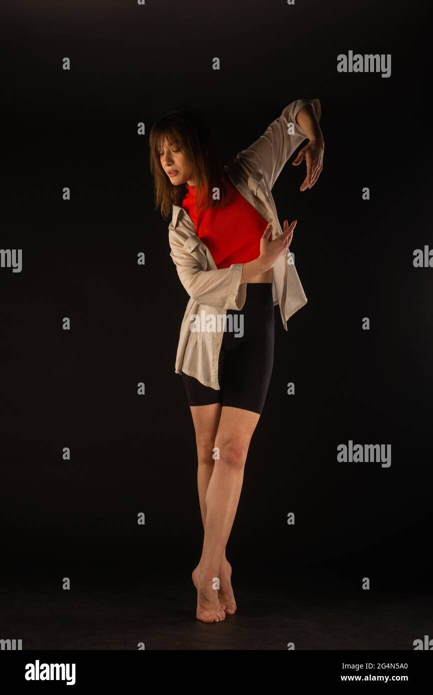 Pretty ballerina is doing a asymmetrical pose while standing and ...