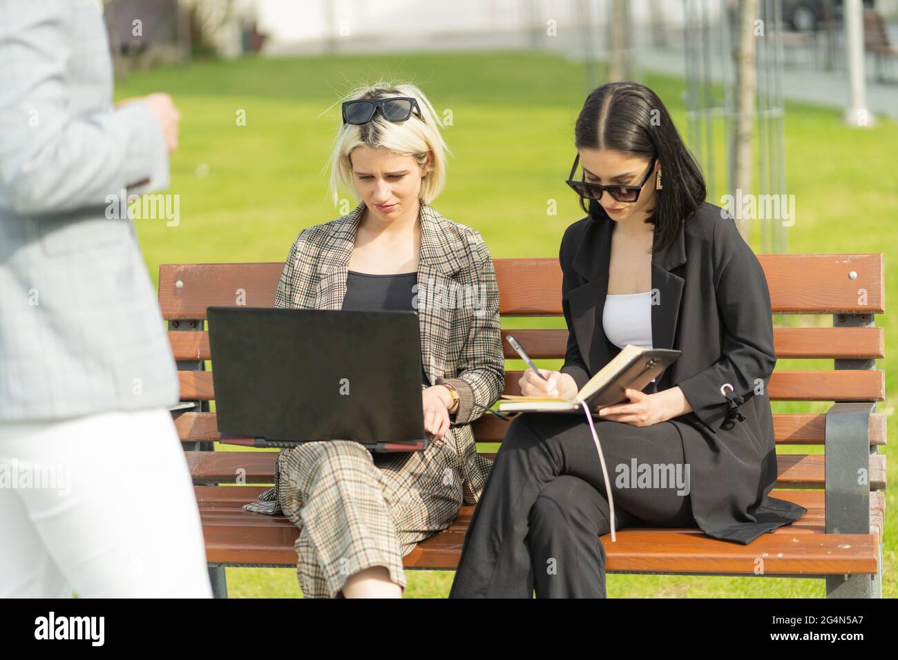 Business people are working so hard outside while sitting on the bench ...