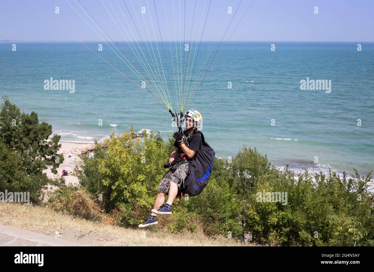 Paraglider pilot in the process of taking off on the beach Stock Photo ...