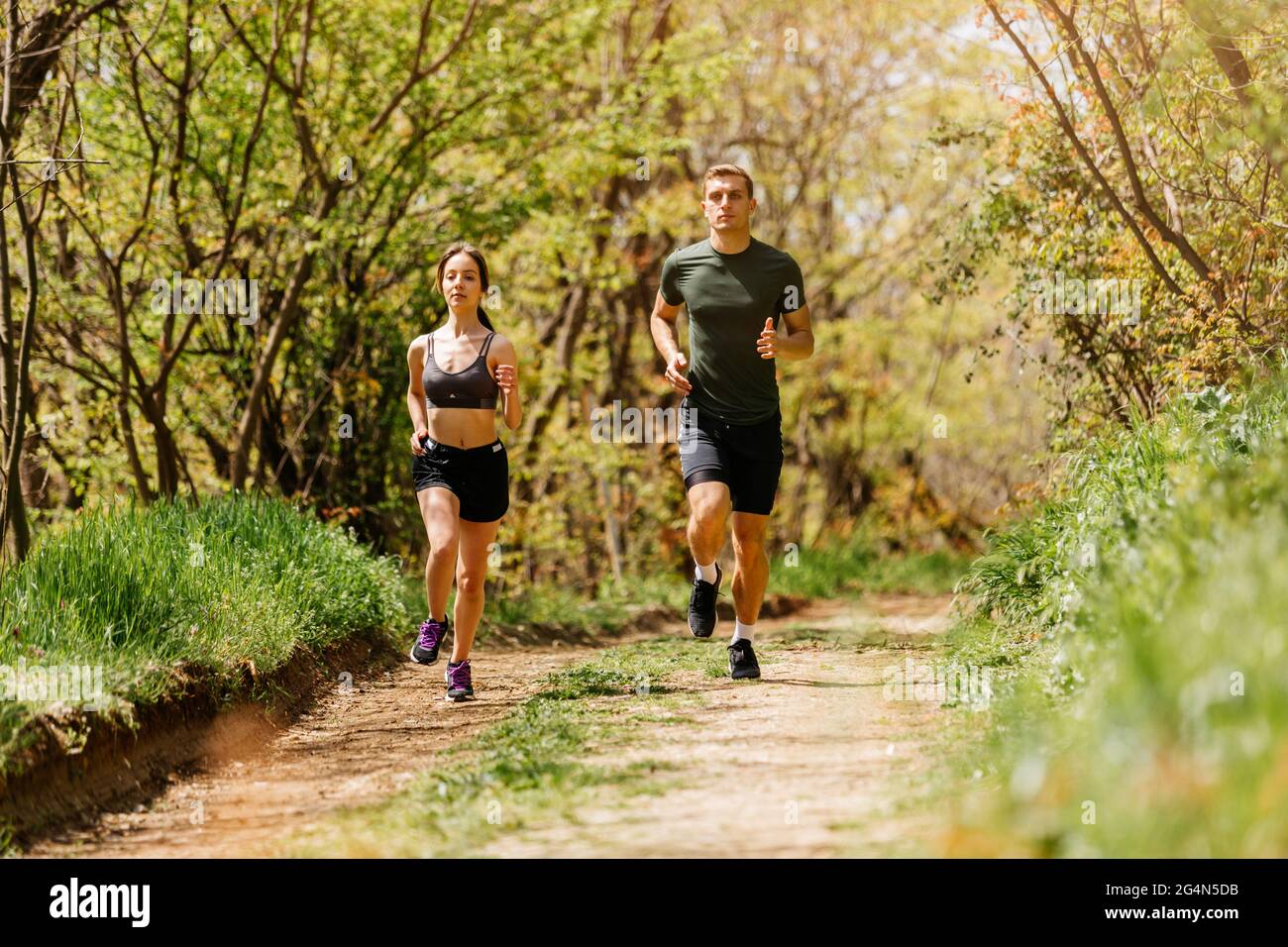 Sport people running in park together. Young couple jogging at outdoor ...