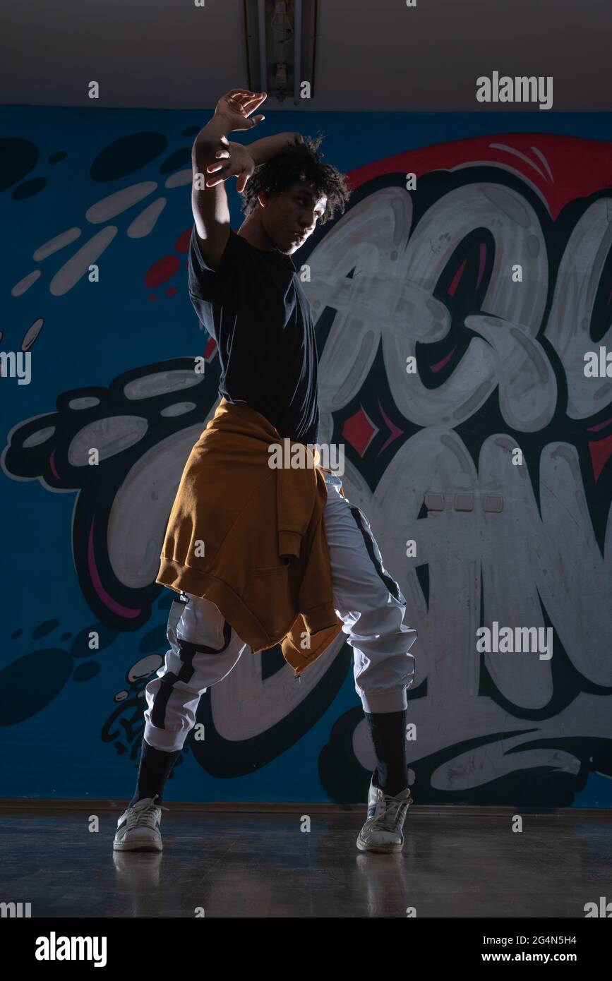 African American hip hop dancer (breakdancer) performing over graffiti ...
