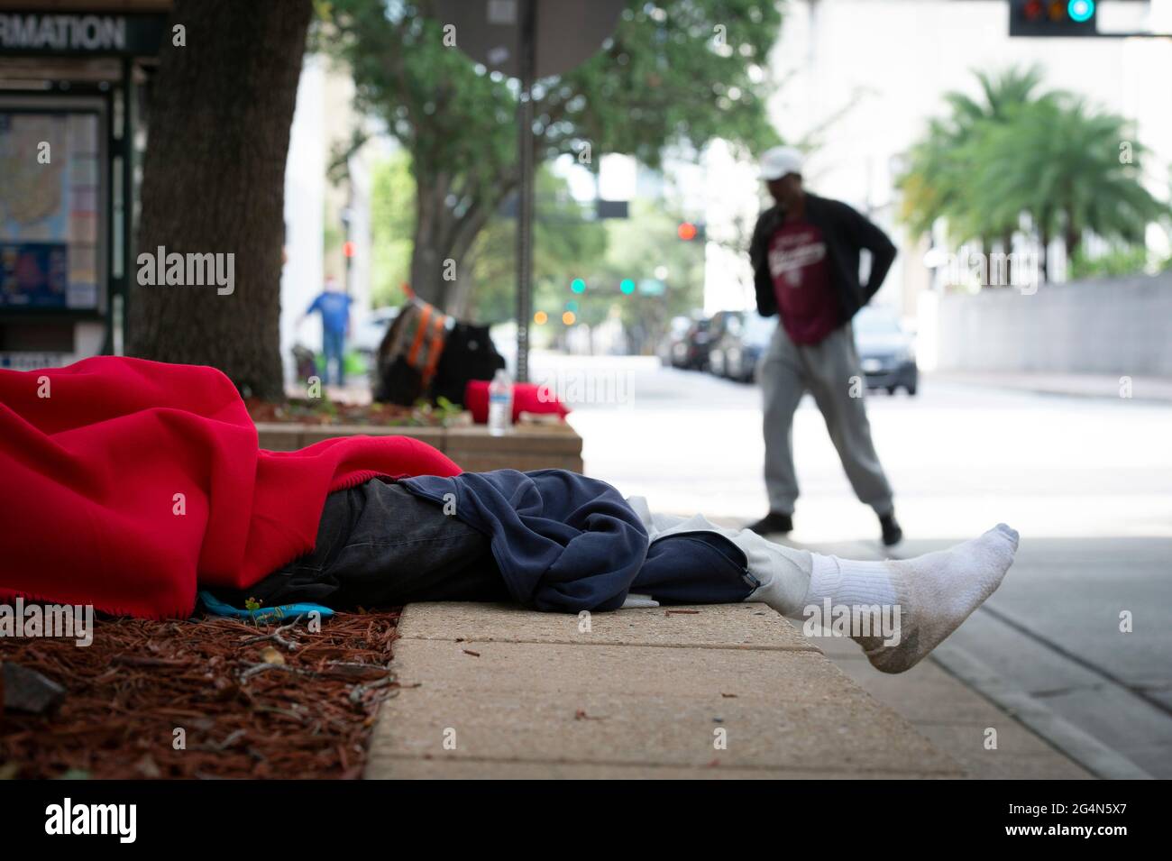 Tampa, FL, USA. 22nd June, 2021. A homeless woman sleeps on a planter ...