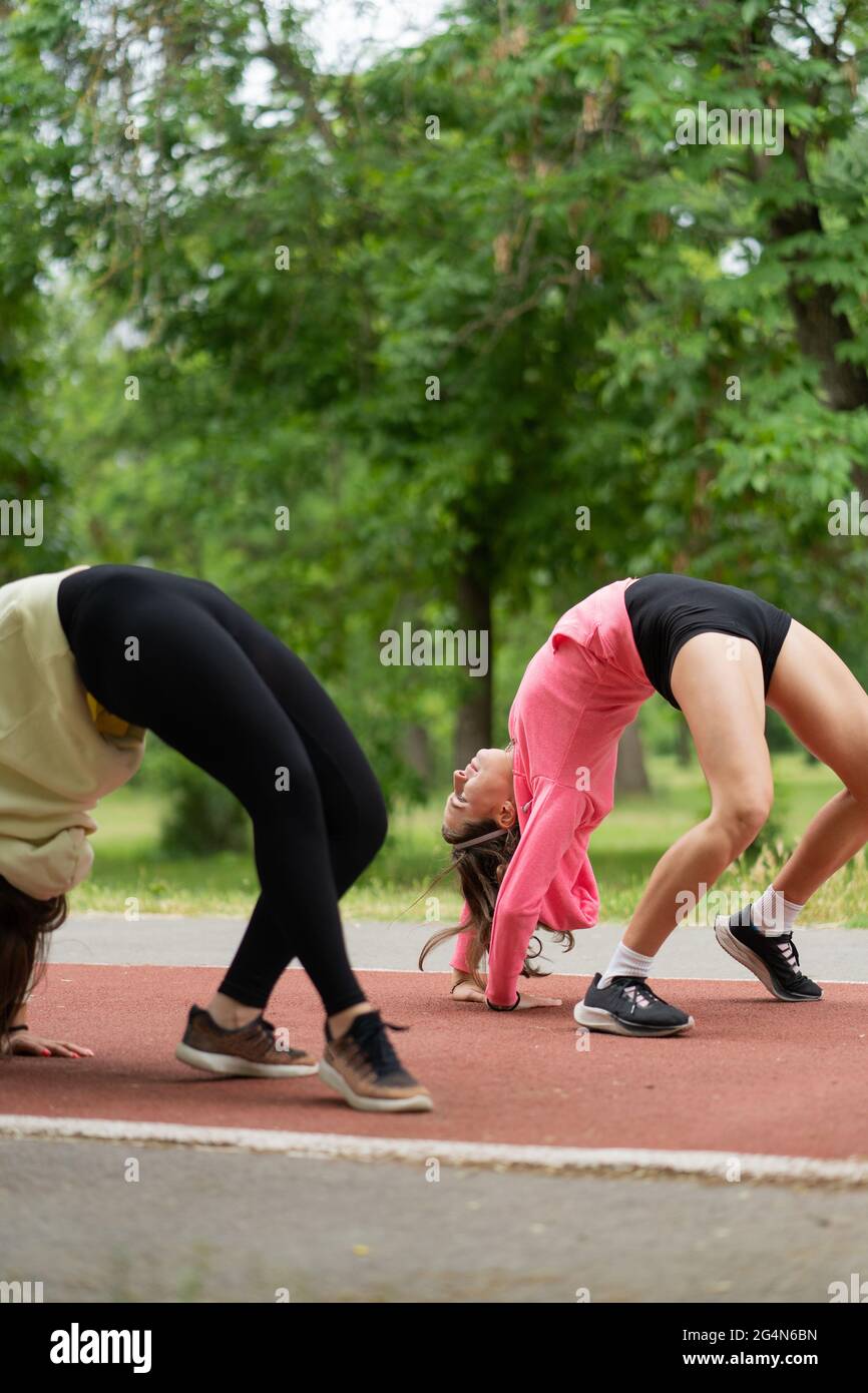 Two attractive and beautiful young girls are bending their back ...