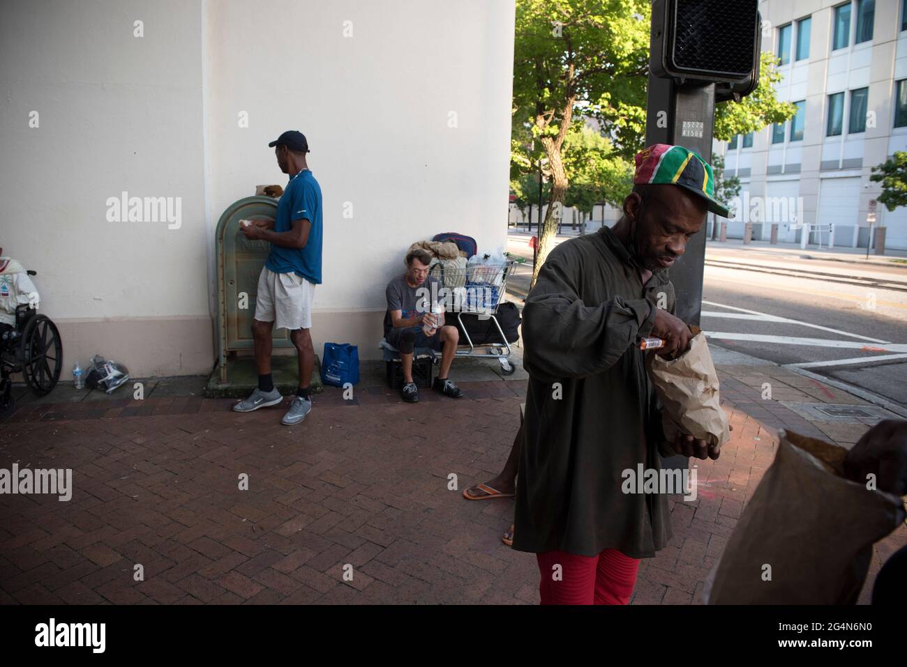 Tampa, FL, USA. 22nd June, 2021. Homeless men enjoy sandwiches ...