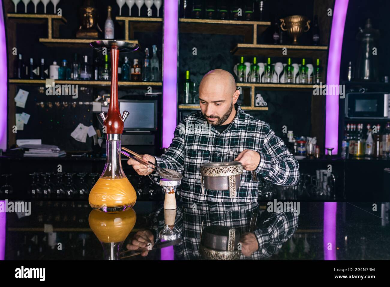 man preparing a big glass traditional hookah in a night club Stock ...