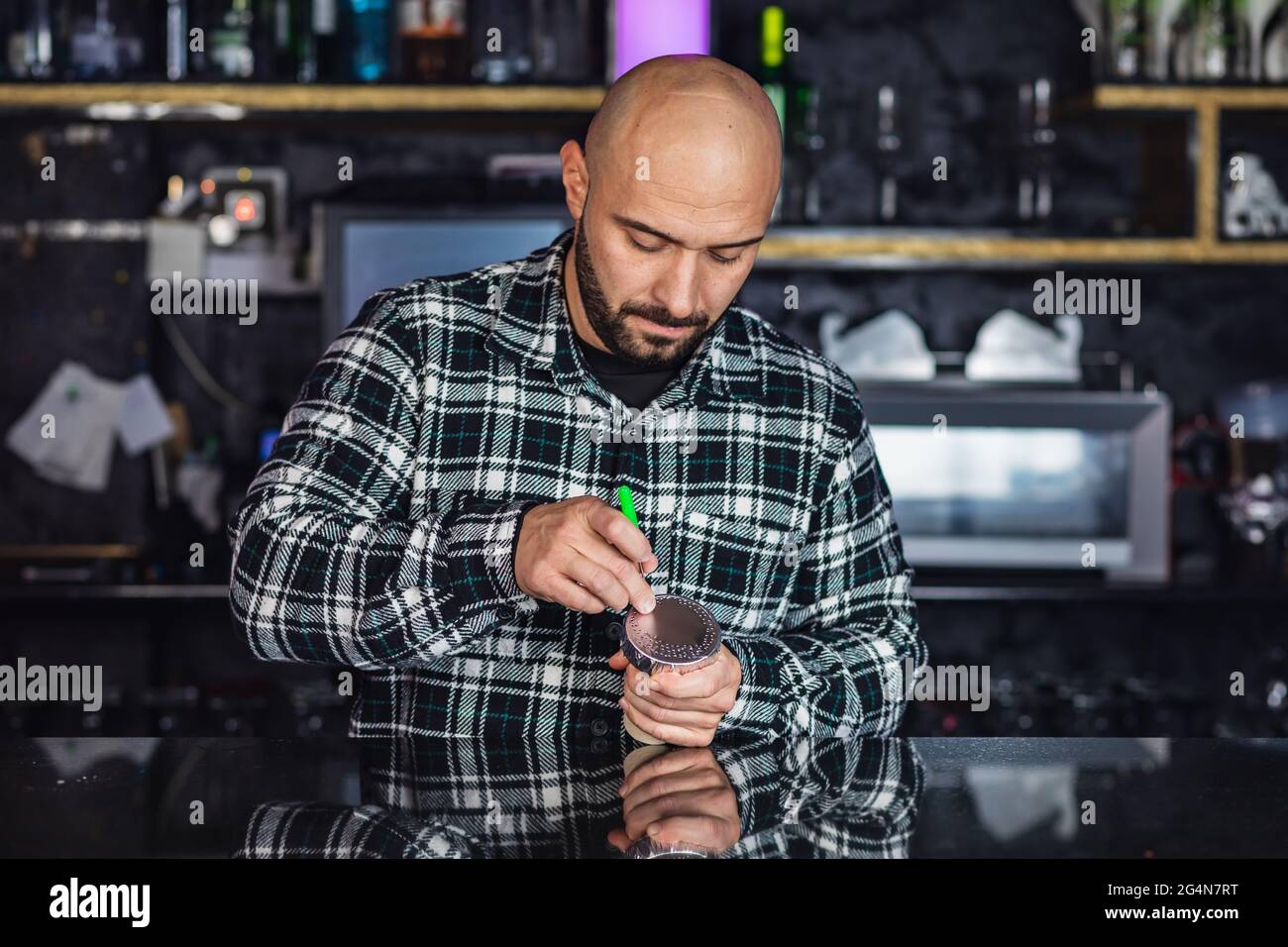 man preparing traditional hookah with foil in a night club Stock Photo ...