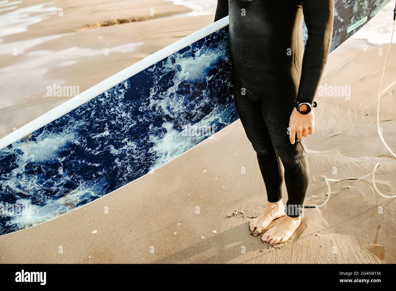 Side view of cropped unrecognizable surfer man dressed in wetsuit ...