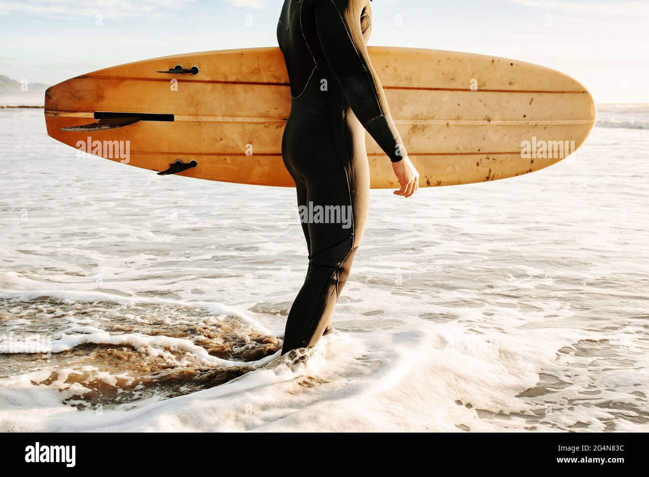 Side view of cropped unrecognizable surfer man dressed in wetsuit ...