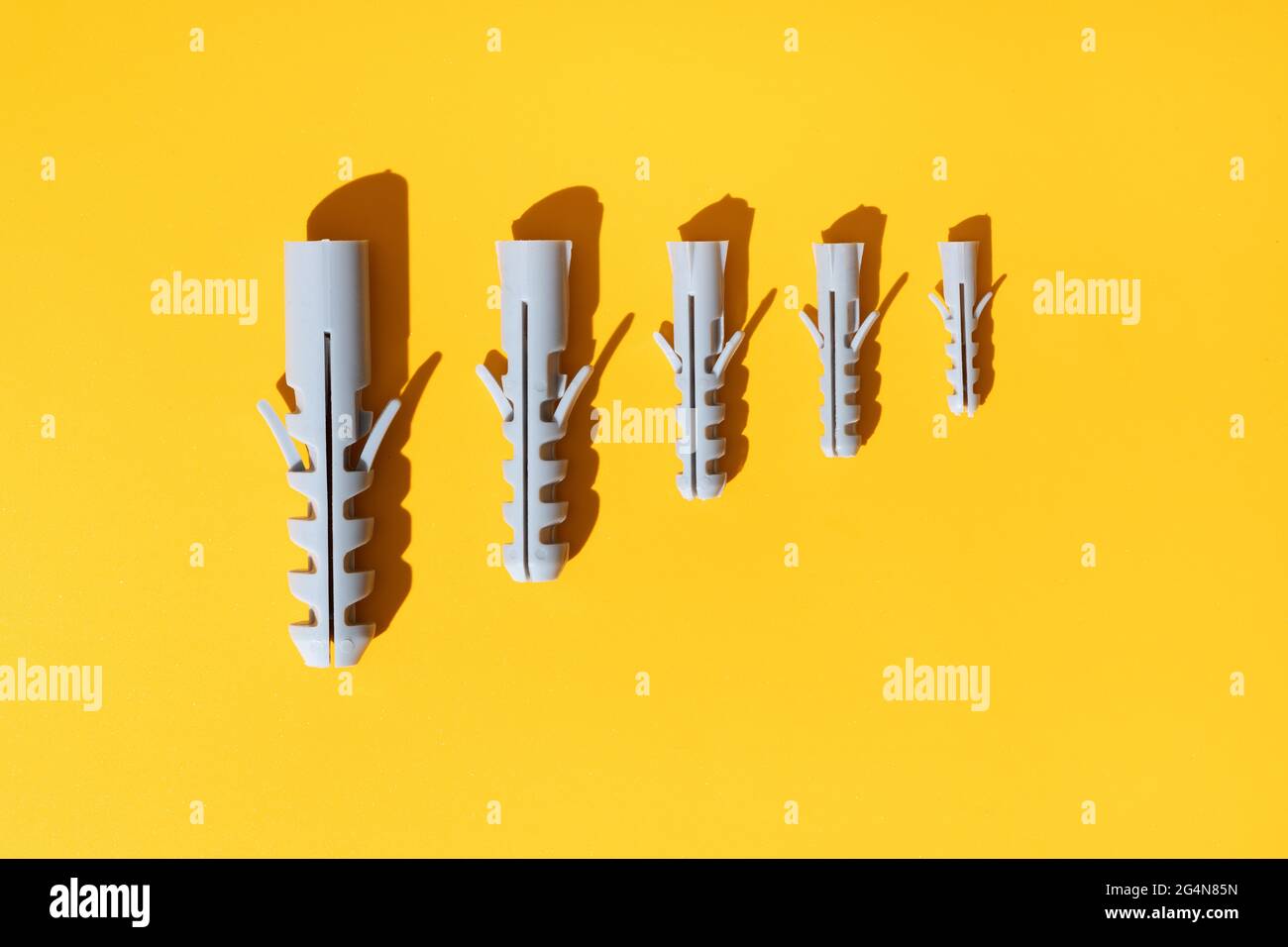 Top view of plastic dowels of different sizes with holes on ribbed ...