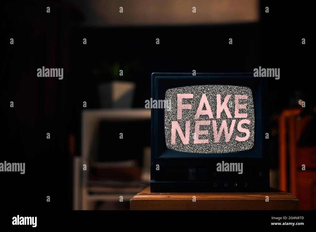 the old vintage tv with gray noise on screen with fake news text ...