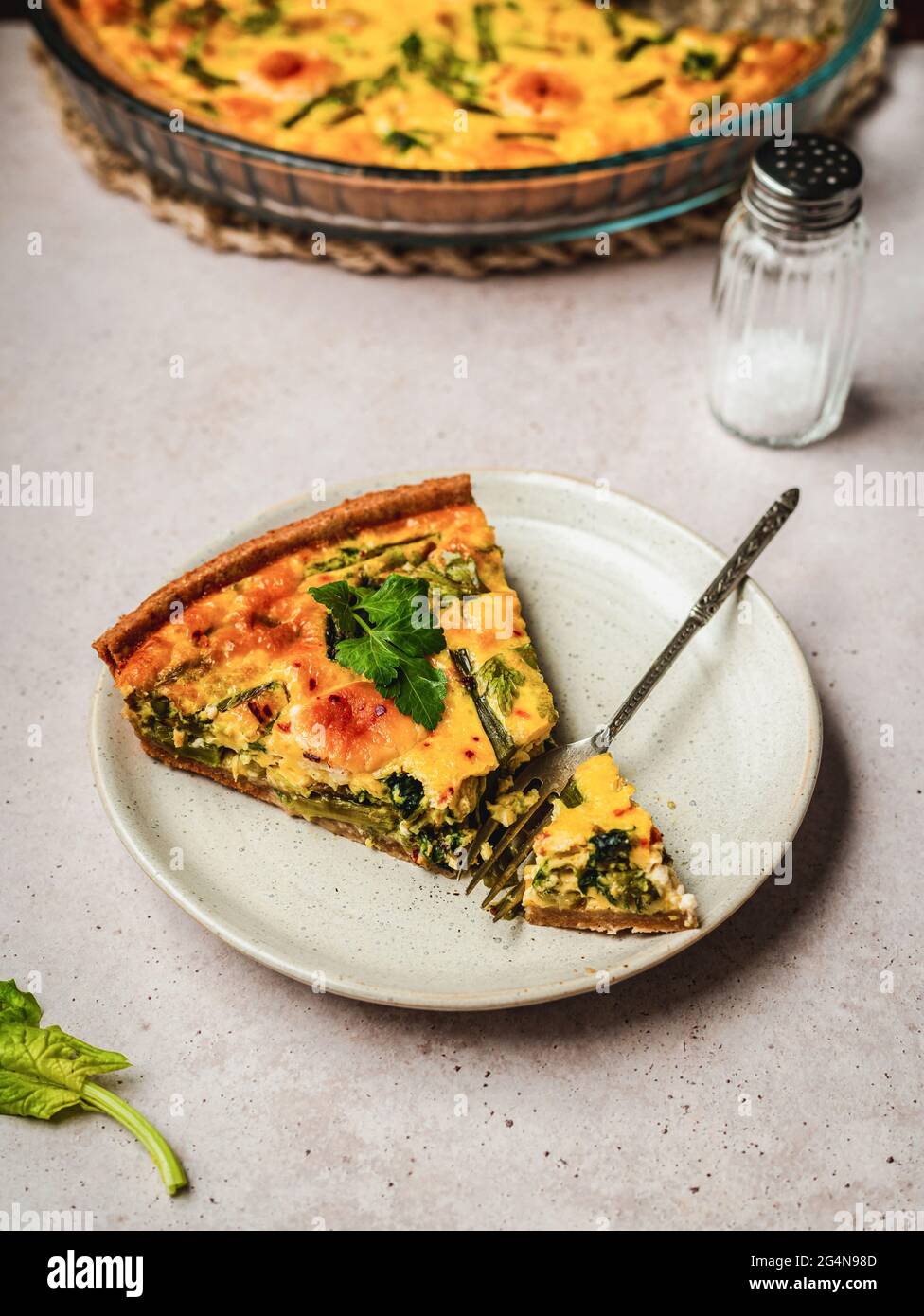 Top view of yummy quiche slice with fresh parsley and asparagus placed ...