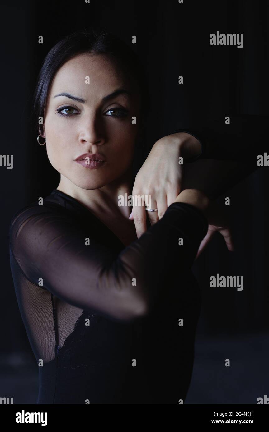 Young graceful Woman in black wear dancing flamenco with raised arms ...