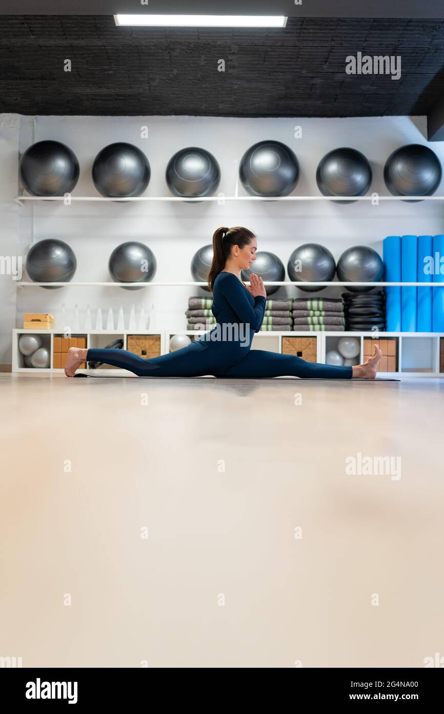 Full body side view of focused young female in activewear doing Front ...
