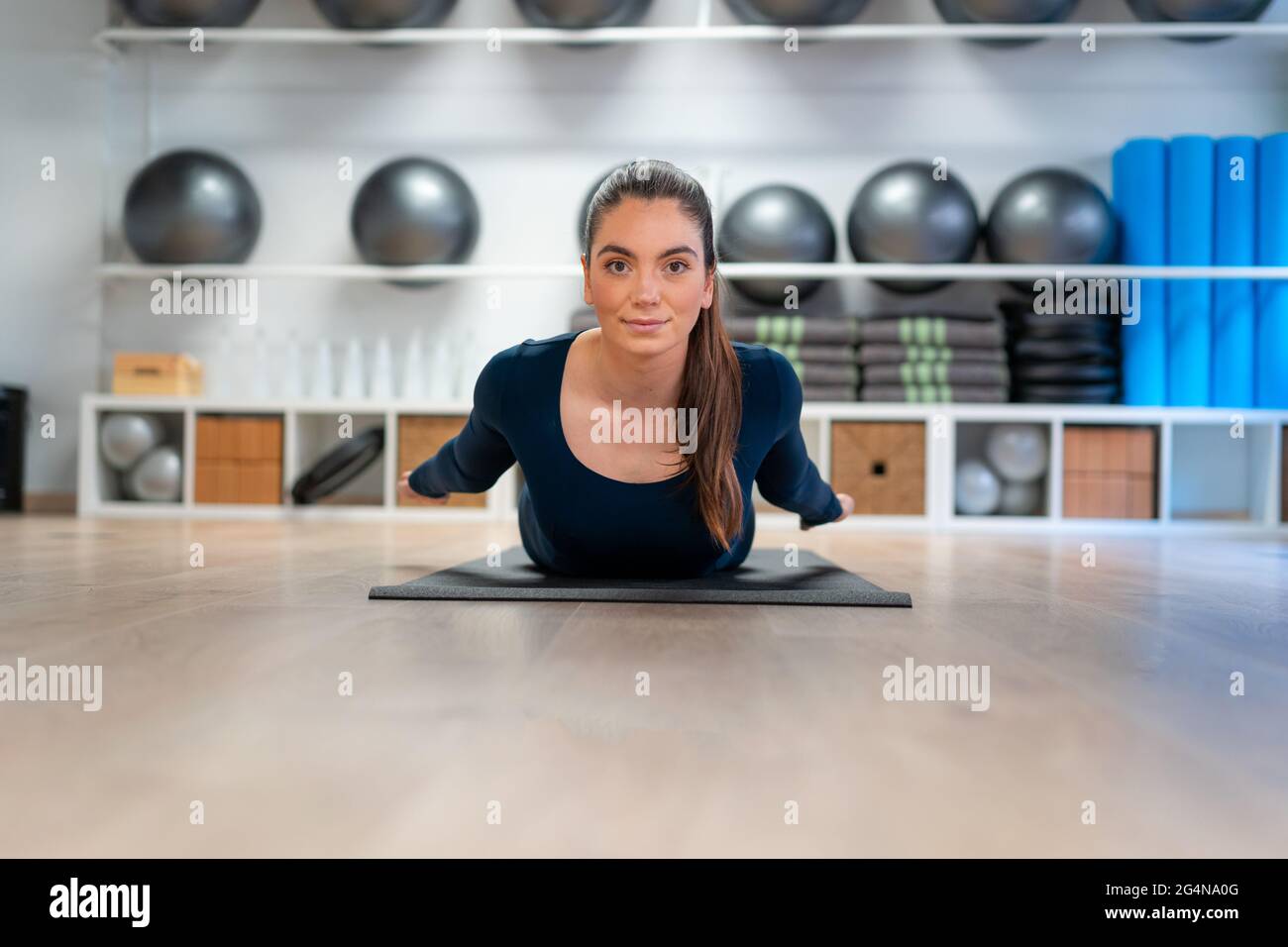 Full body of young female doing Locust pose while practicing yoga in ...