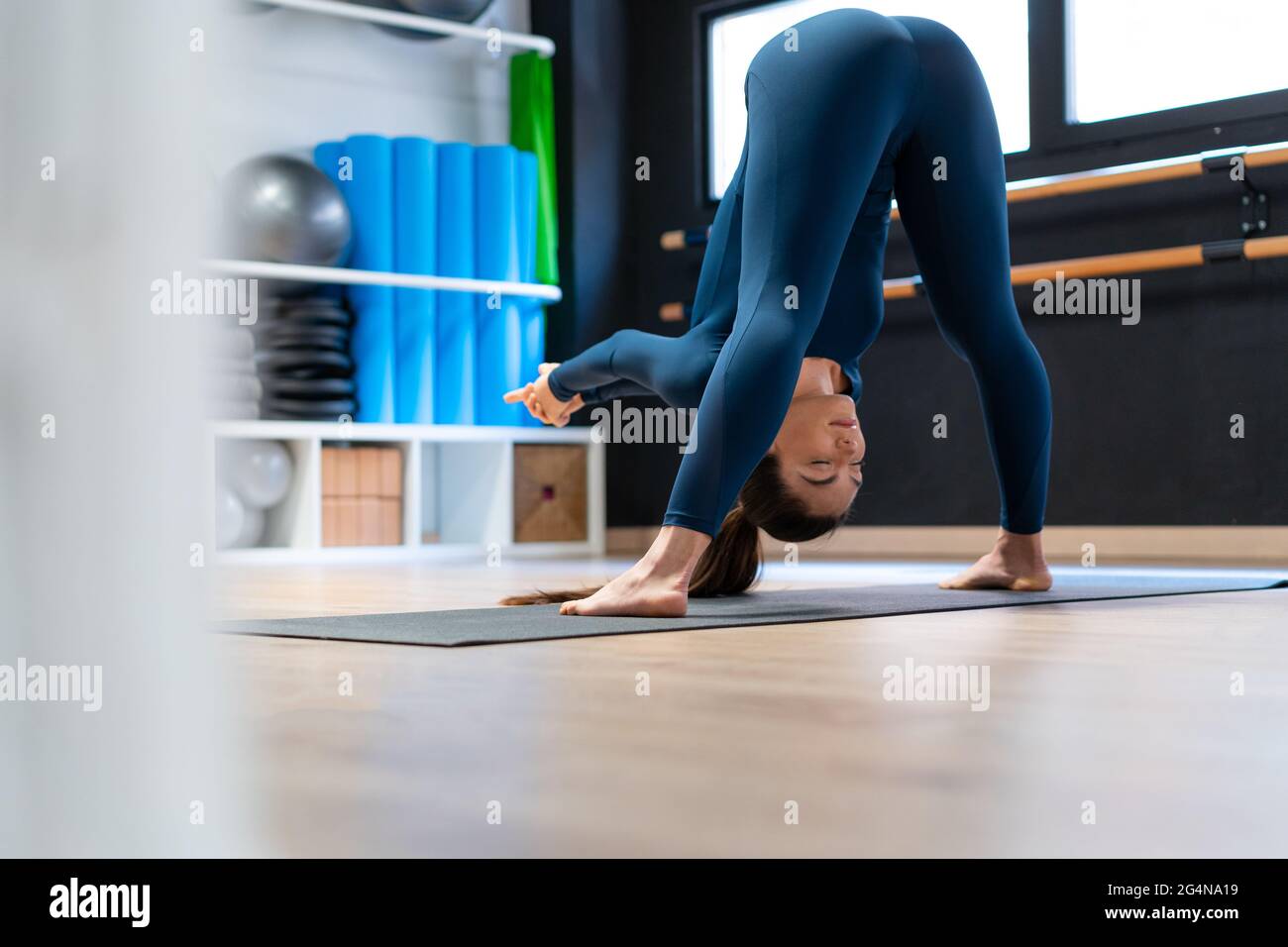 Full body back view of focused flexible young female doing Standing ...