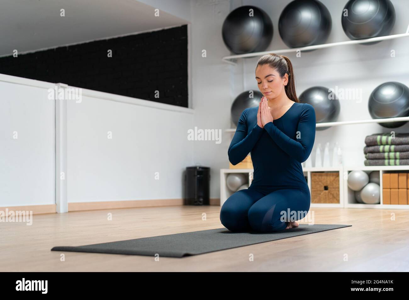 Full body of calm concentrated young female sitting in Hero pose with ...
