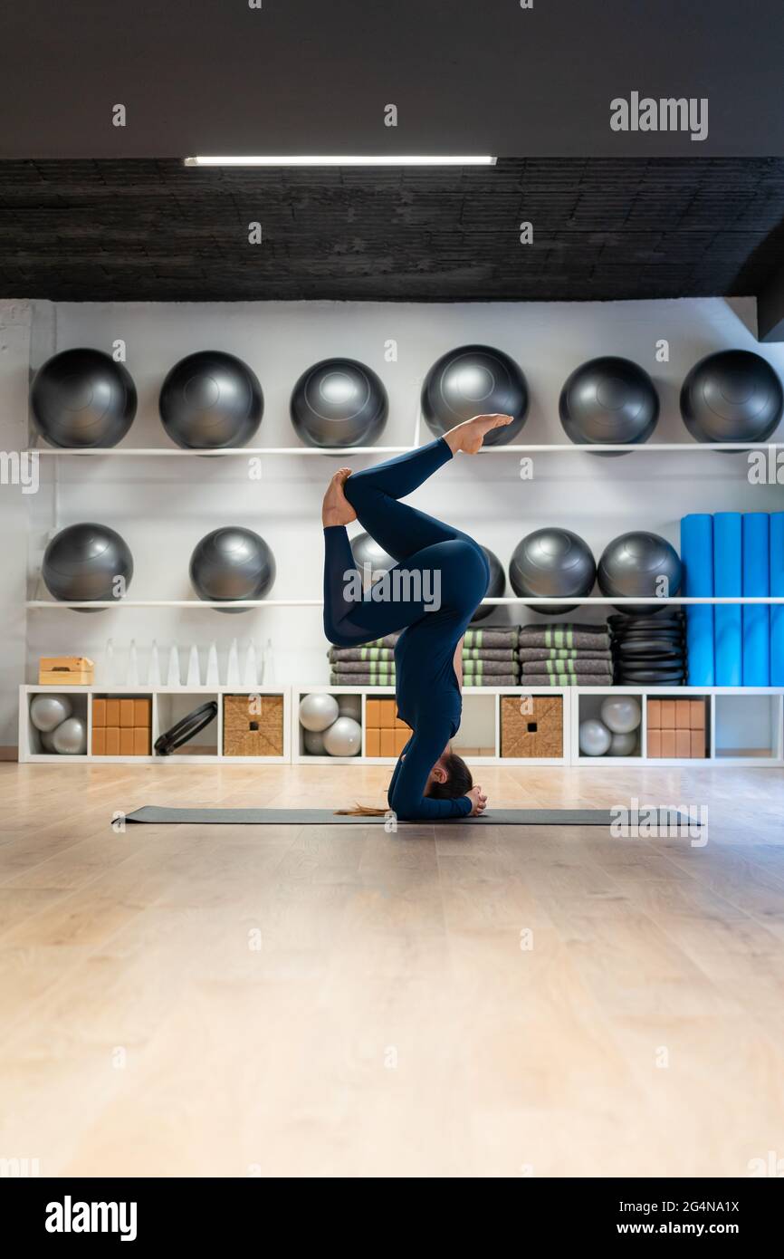 Full body side view of fit female in sportswear doing supported ...