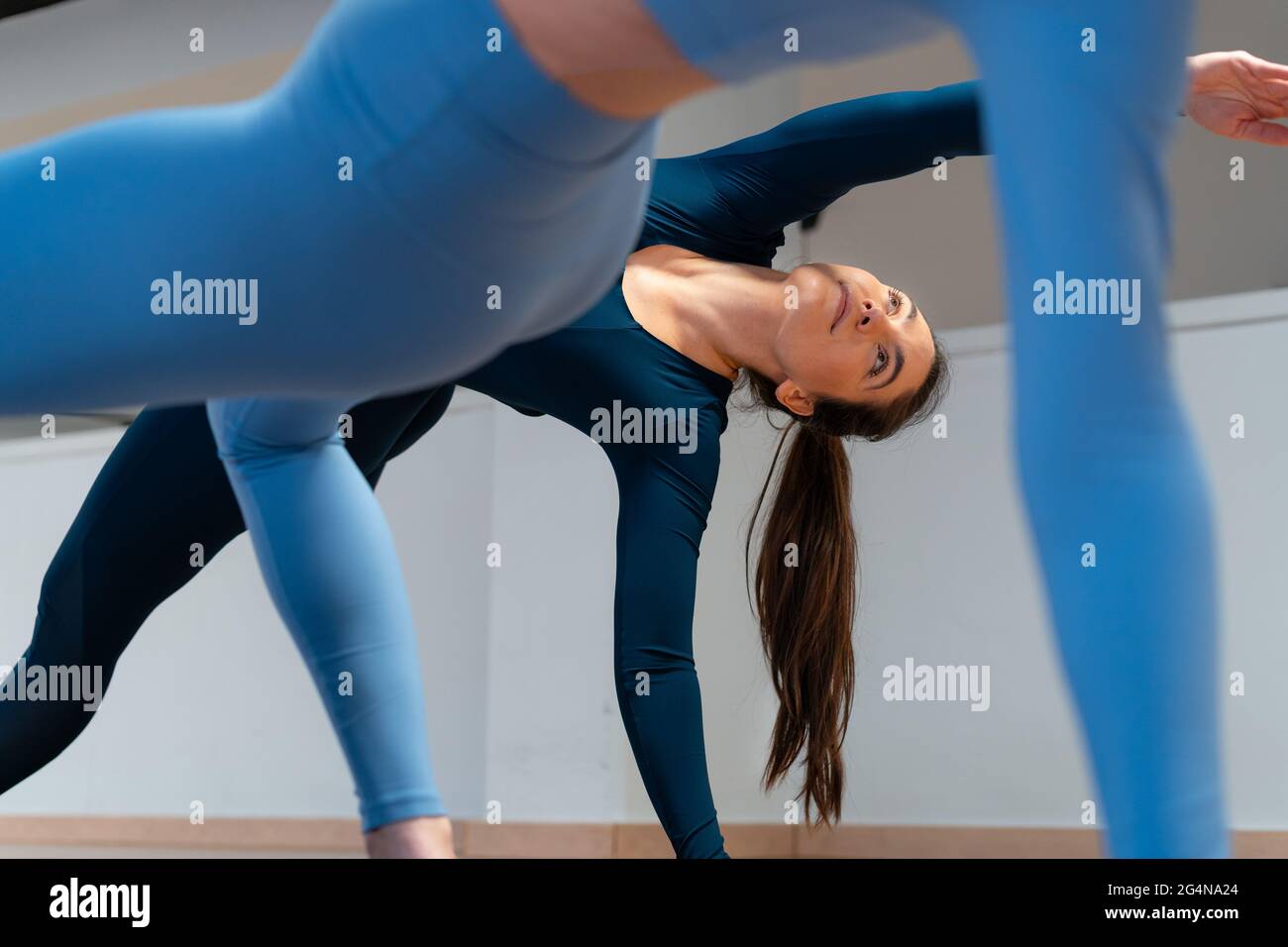 Side view of young flexible female stretching body in backbend twist ...