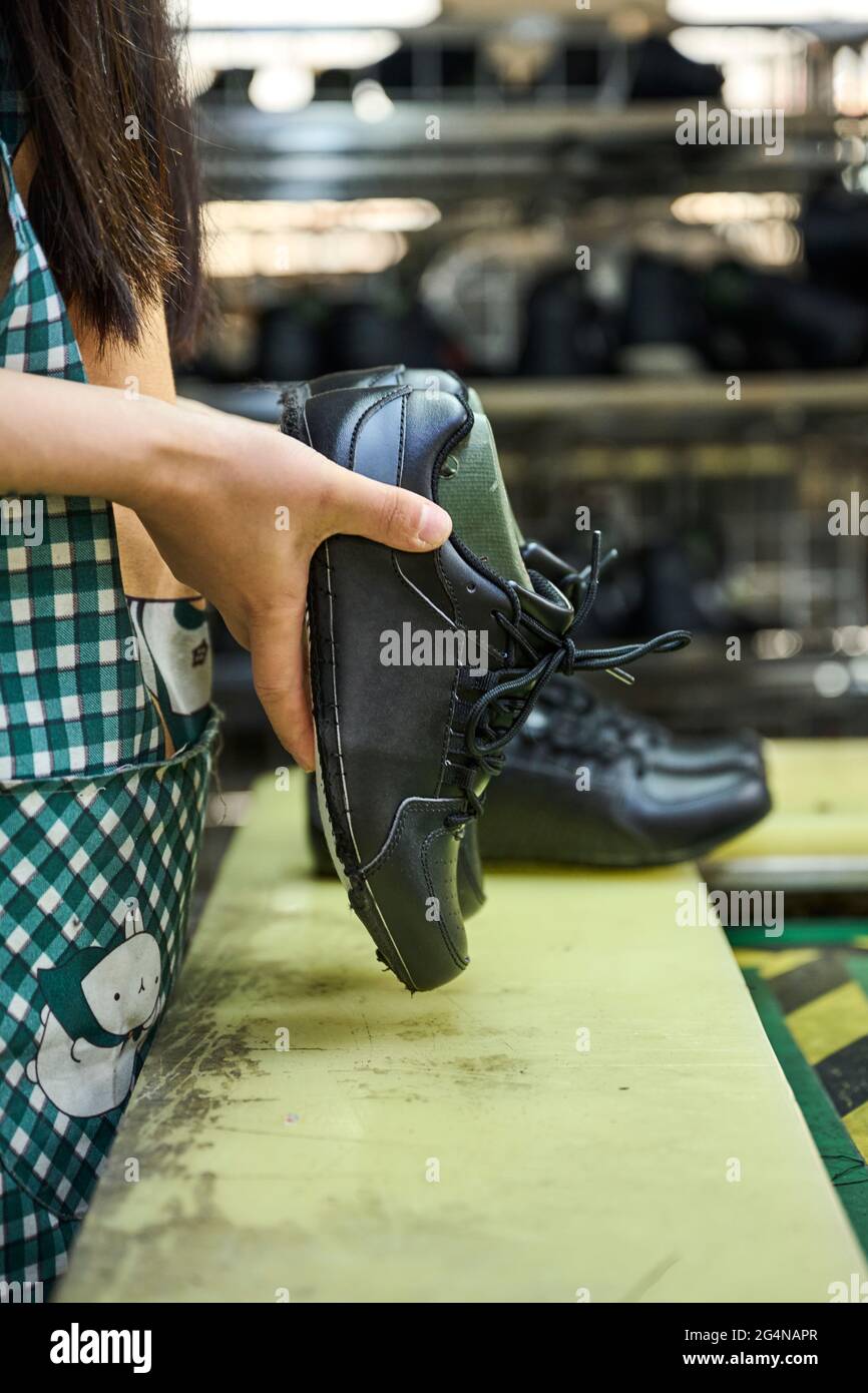 Detail of Woman's hands while checking the shoes in quality control ...