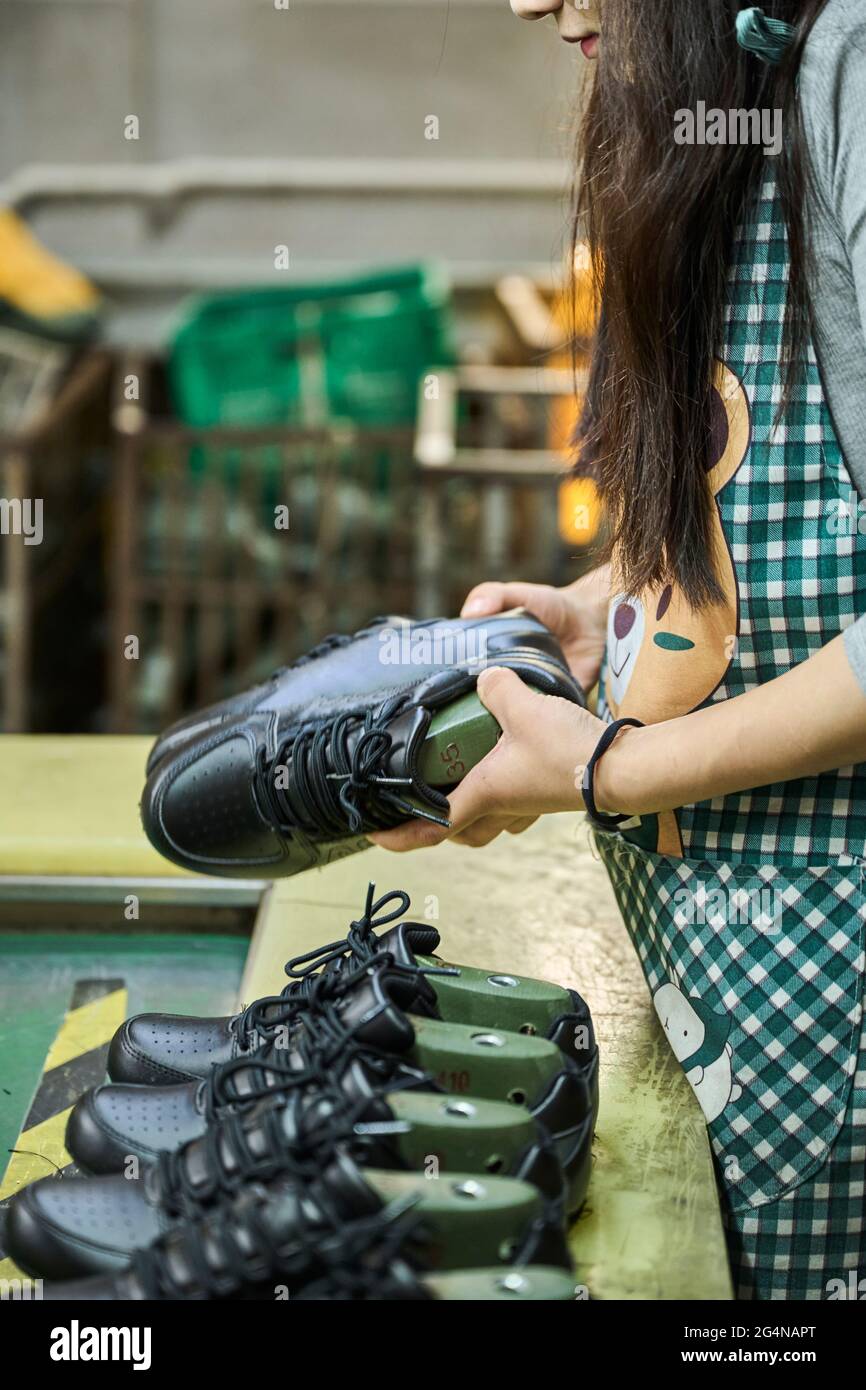 Detail of Woman's hands while checking the shoes in quality control ...