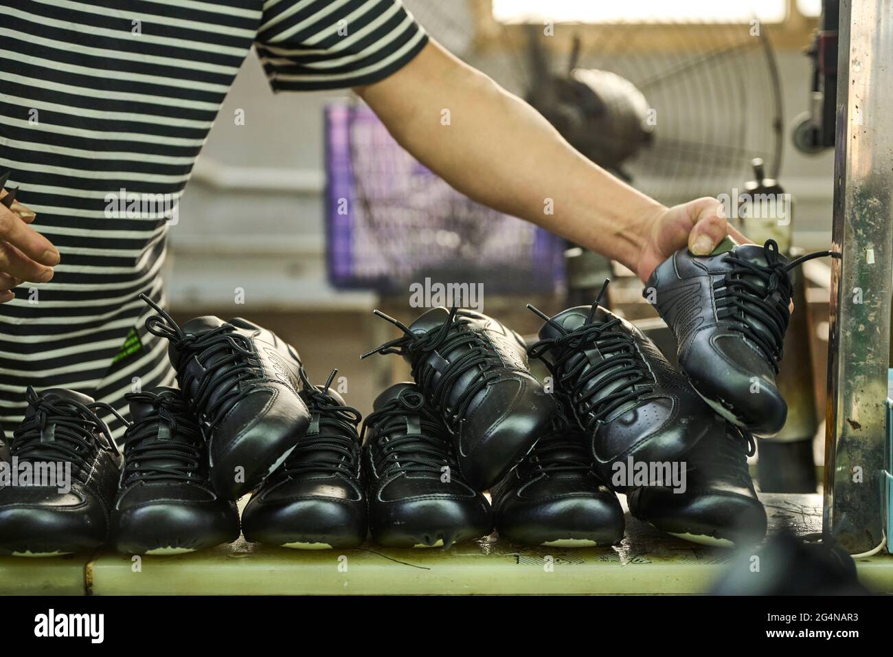 Detail of man's hands while checking the shoes in quality control ...