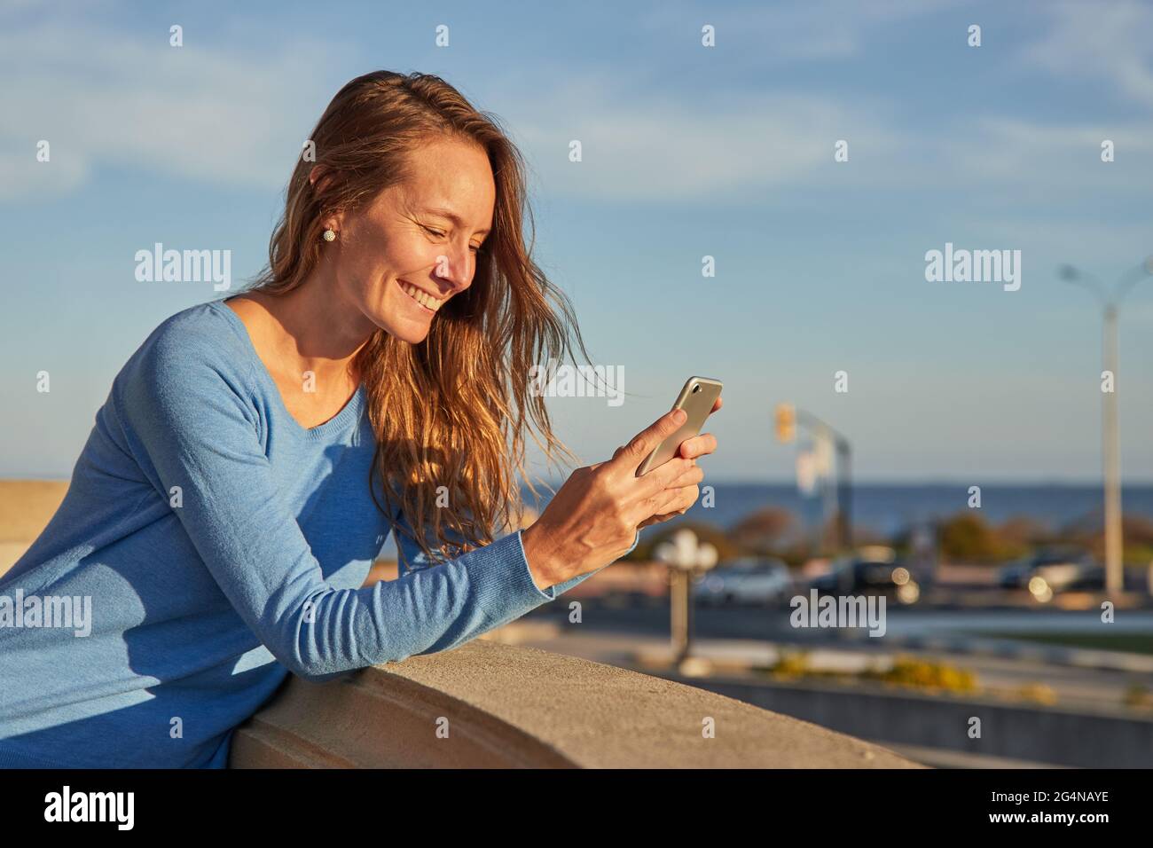 Side view of young happy female surfer in wetsuit lying on waving ...