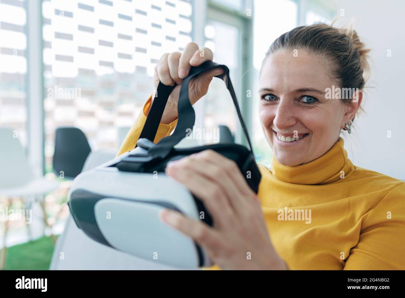 Female in casual outfit sitting on sofa and using VR goggles near ...