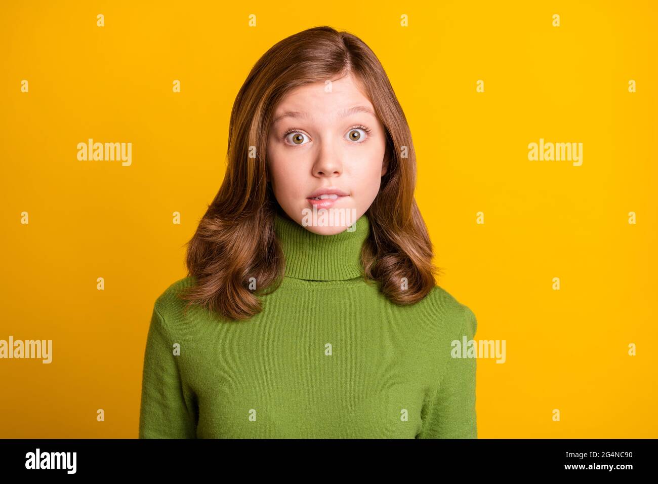Photo portrait young girl in green turtleneck surprised biting lip ...