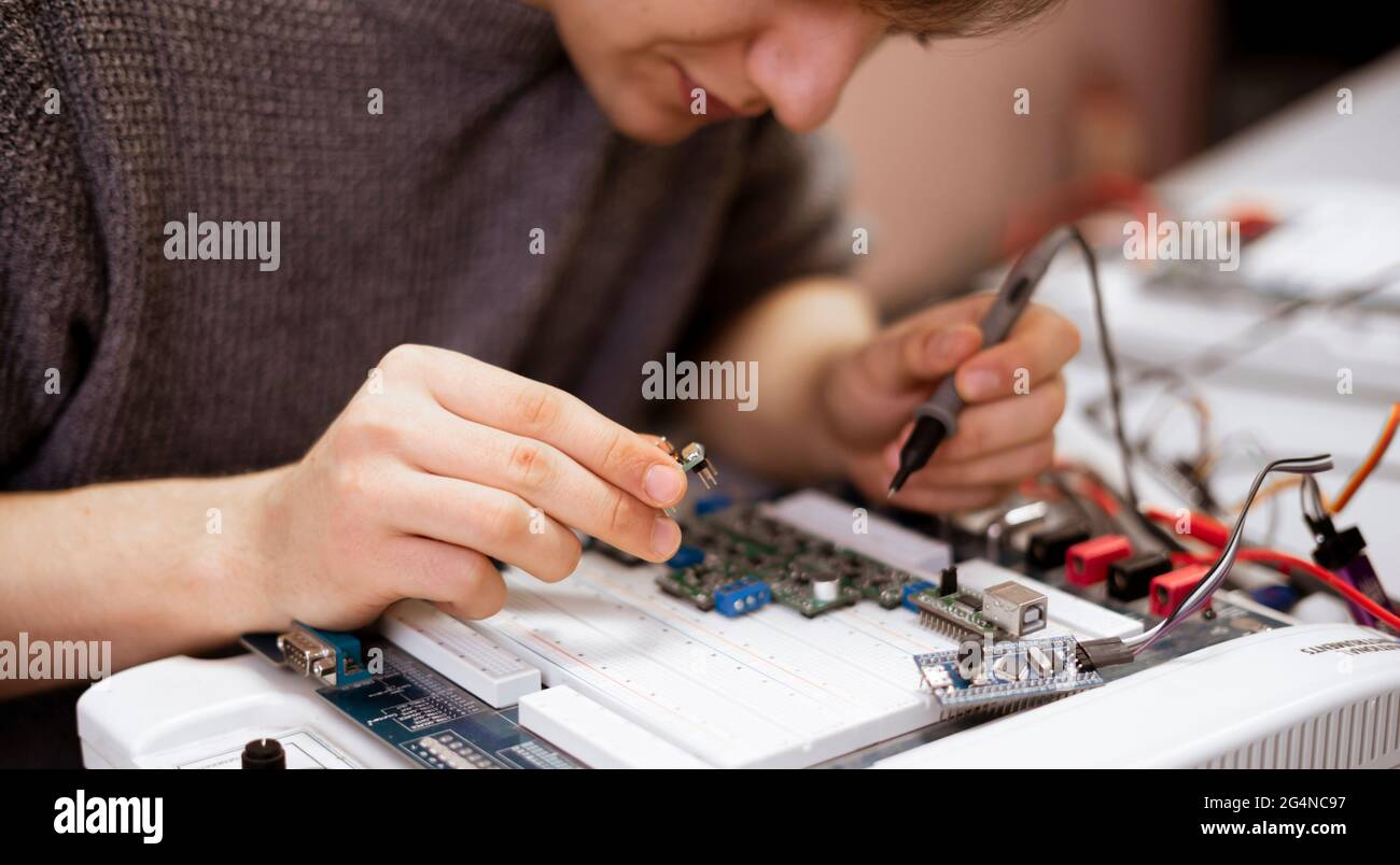 student making measurement and costruct the circuit board with engineer ...