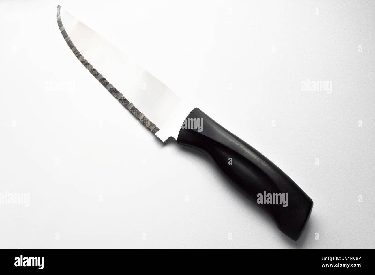 Very sharp serrated chrome metal knife with plastic handle, isolated on ...