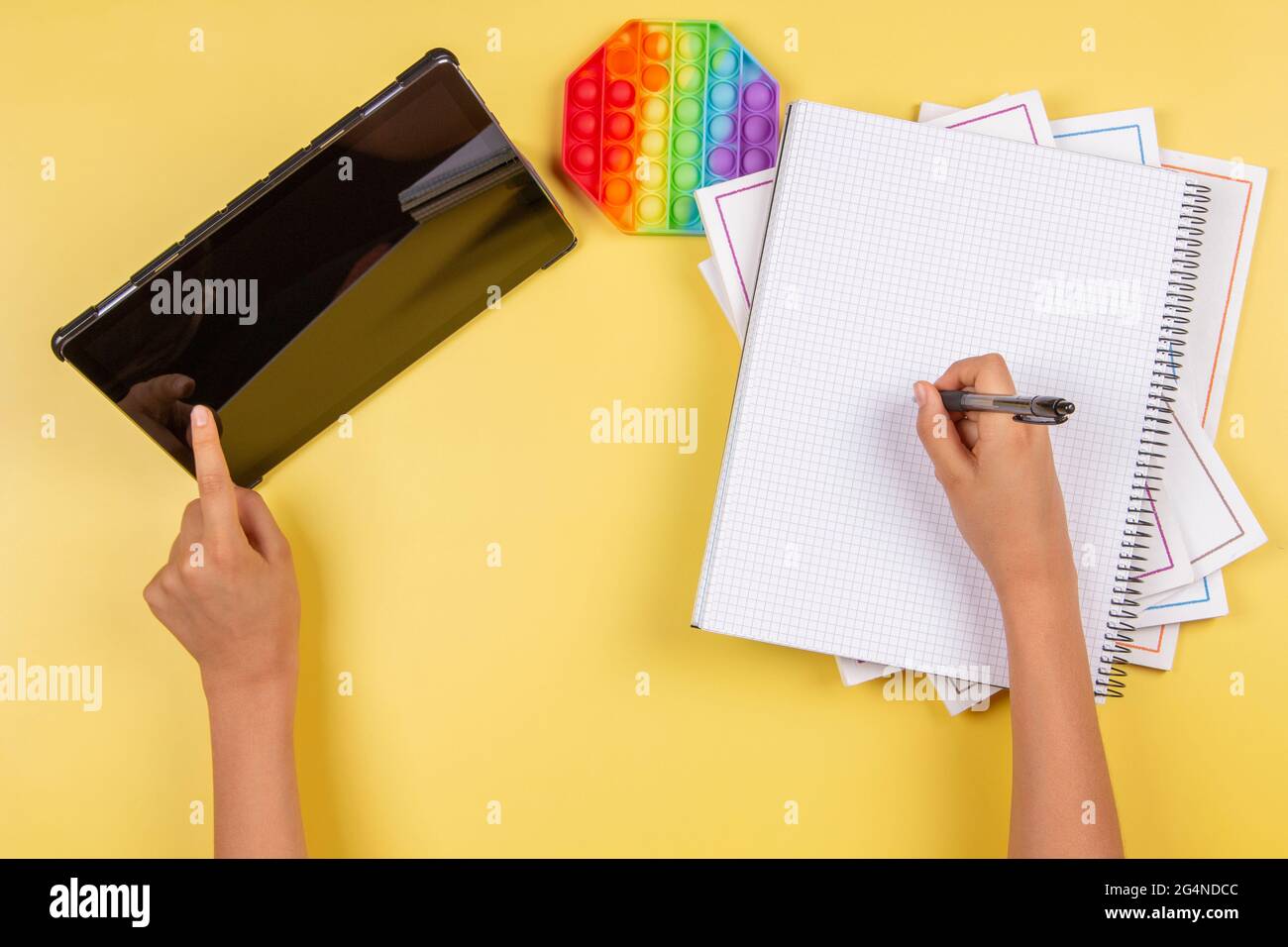 Kid learning, doing homework, using tablet computer. School books and ...