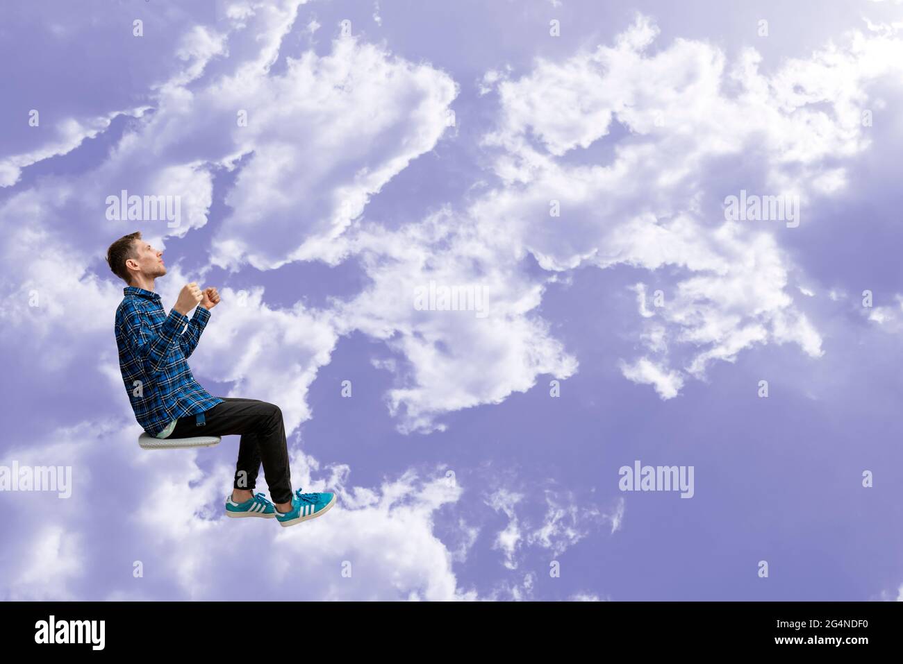 flying high in the sky with clouds, man on a swing, relax and dream in ...