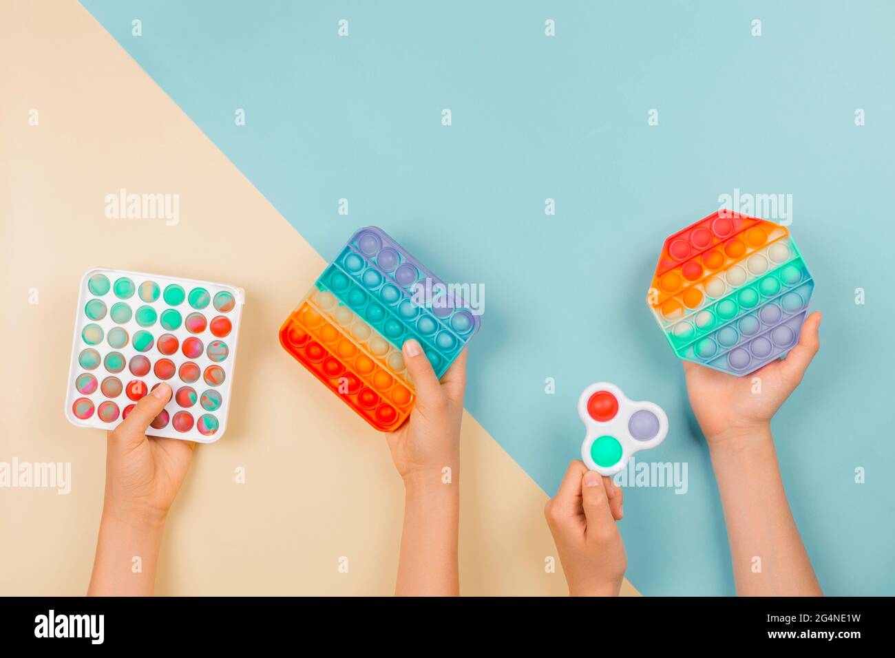 Many hands holding trendy pop it fidget toys on background. Push pop-it ...