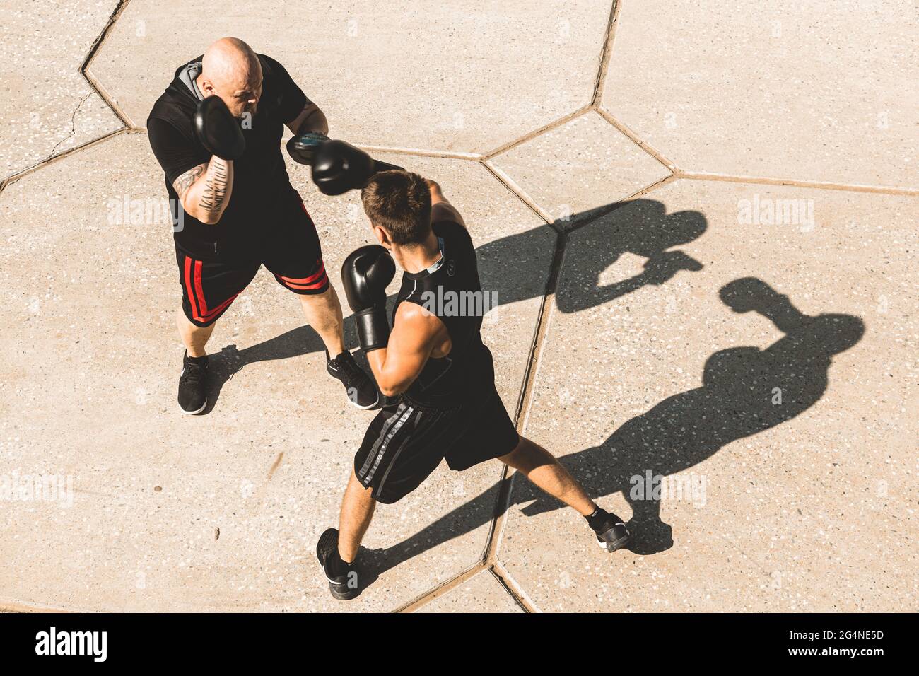 Two men exercising and fighting in outside. Boxer in gloves is training ...