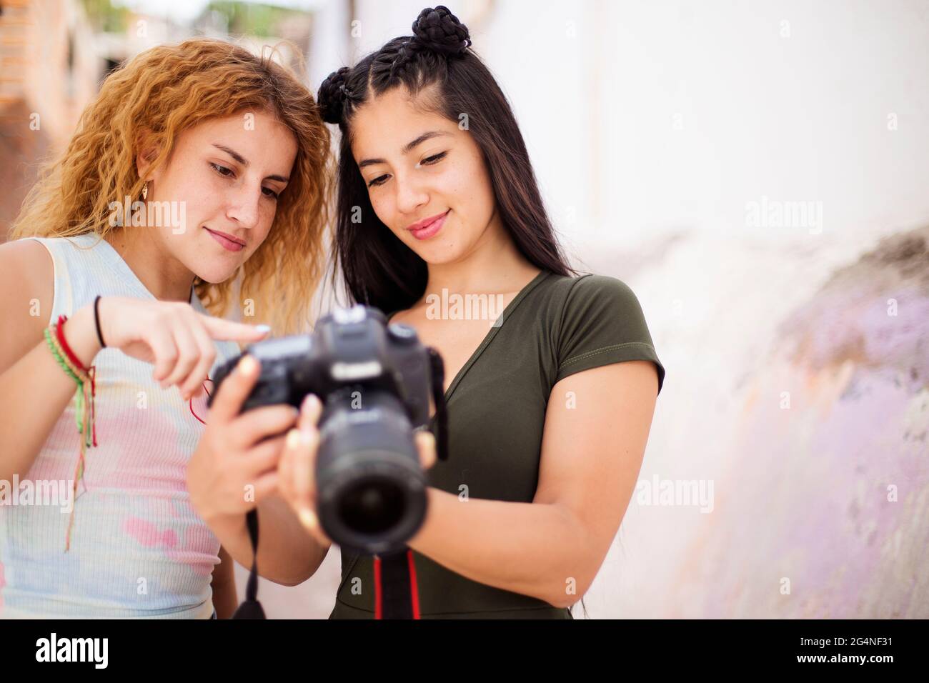 two women friends watching the display of a dslr camera Stock Photo - Alamy