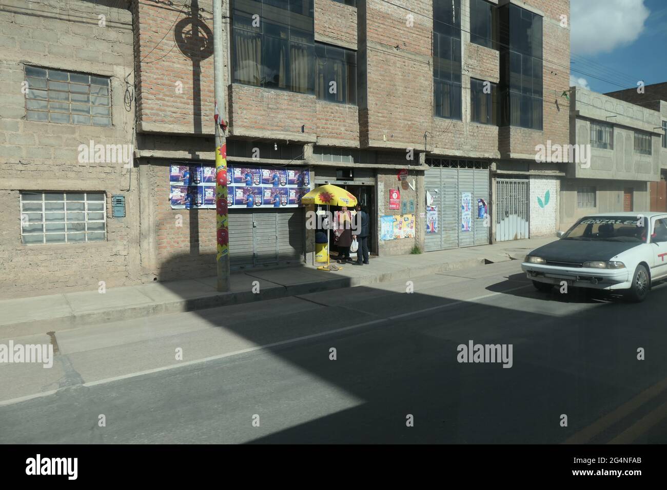 Street in Peru with umbrella car posters poster sign signs reflection ...
