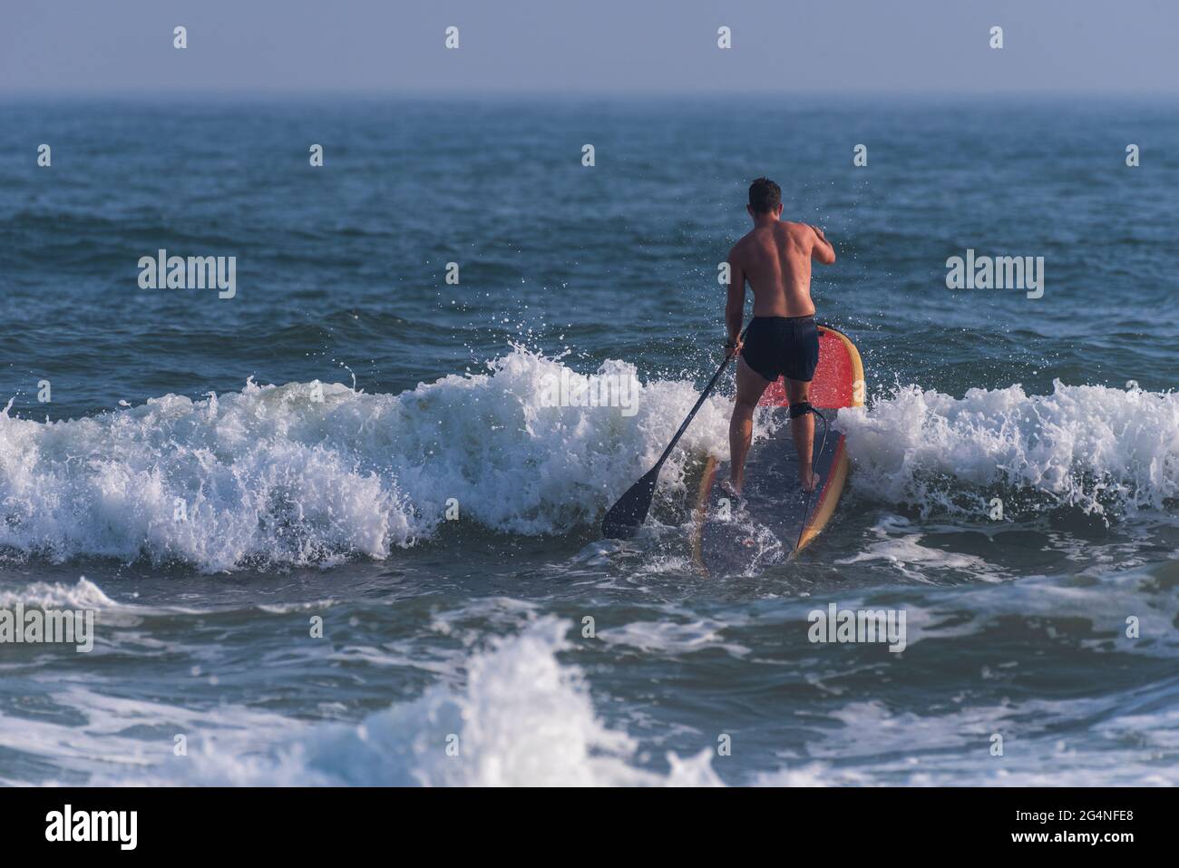 A man surfs near the beach at the Johnson Beach National Seashore in ...