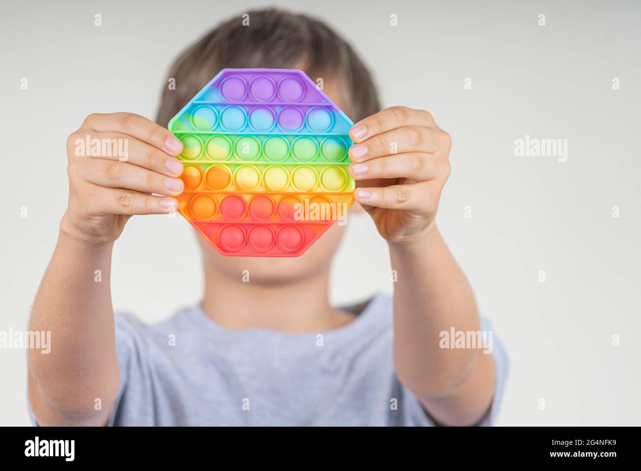 Boy holding sensory pop it fidget toy in his hands. Push pop-it ...