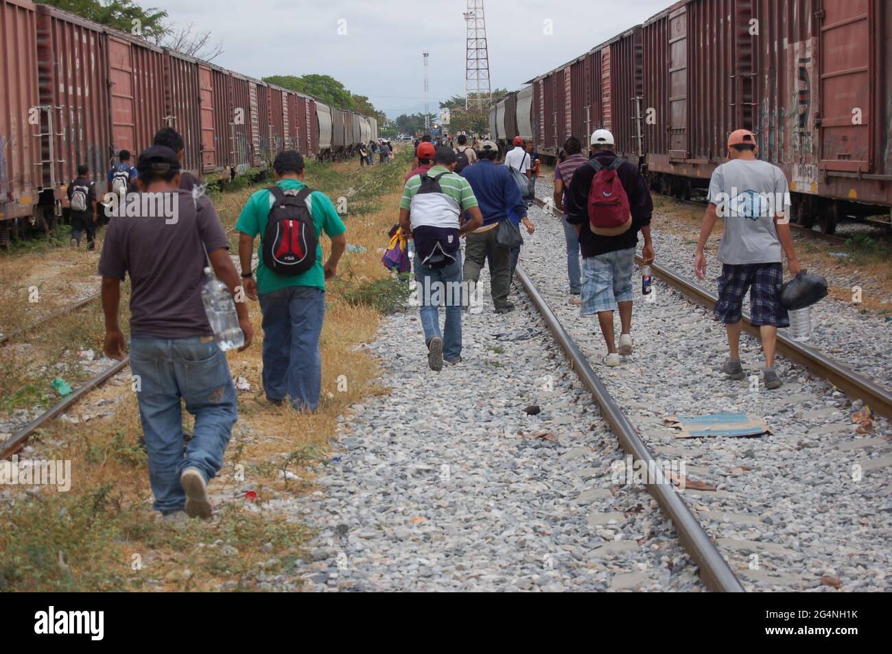 Central Americans walking along train tracks Stock Photo - Alamy