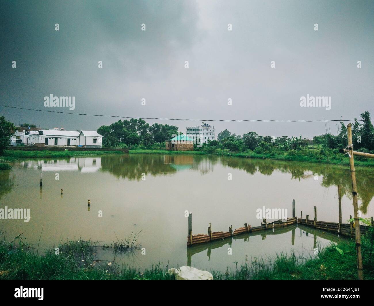 Yellow river with surrounding greenery under clouds Stock Photo - Alamy