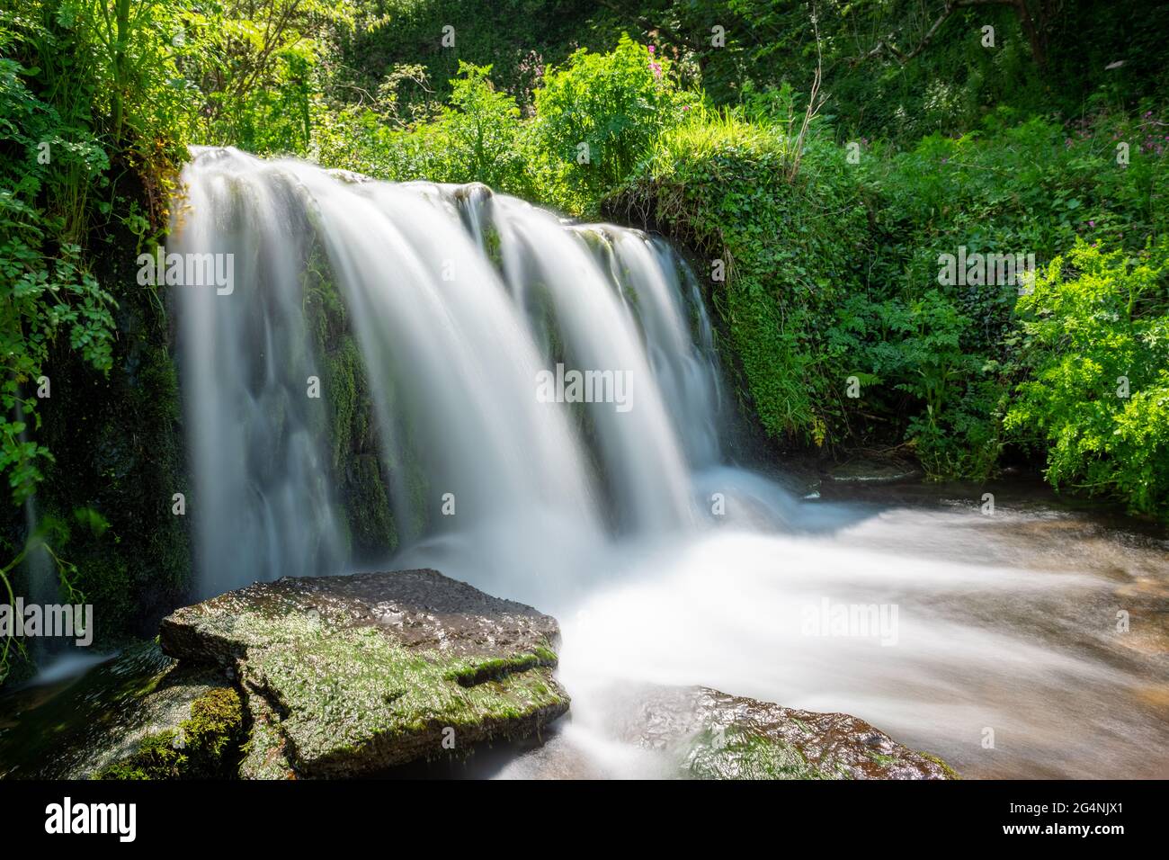 Long exposure of a waterfall flowing onto Lee Abbey Beach in Devon ...