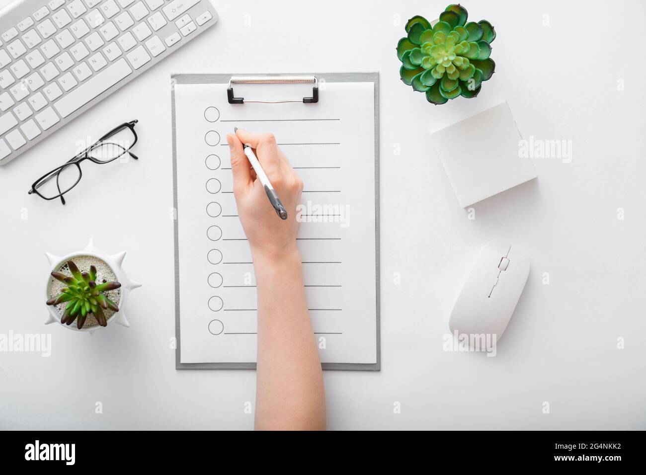 Handwriting on empty list in notepad to do list. Female hands do notes ...