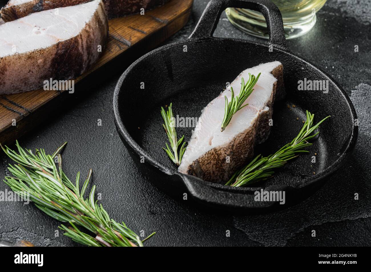Sliced Halibut fish set, with ingredients and rosemary herbs, on black ...