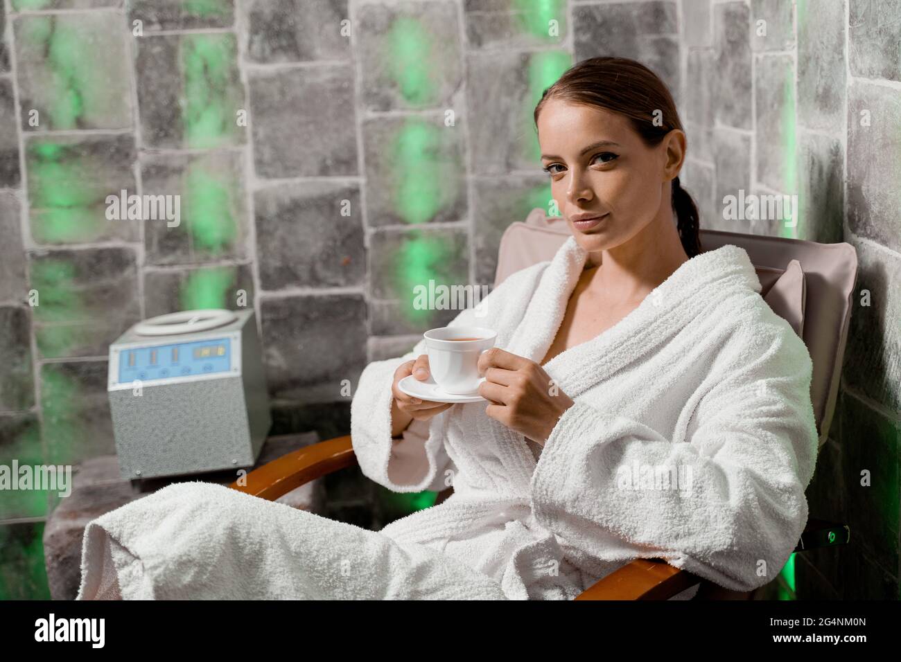 Inhalation therapy in salt room in spa. Young woman with cup of tea ...