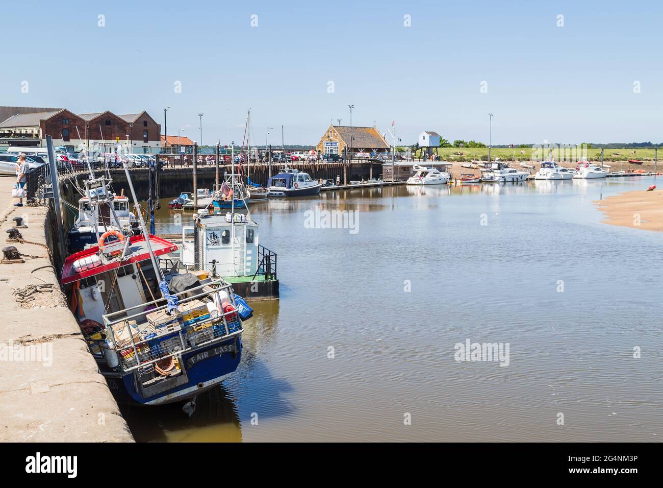Fishing boats line the quay at Wells next the Sea seen at low tide in ...
