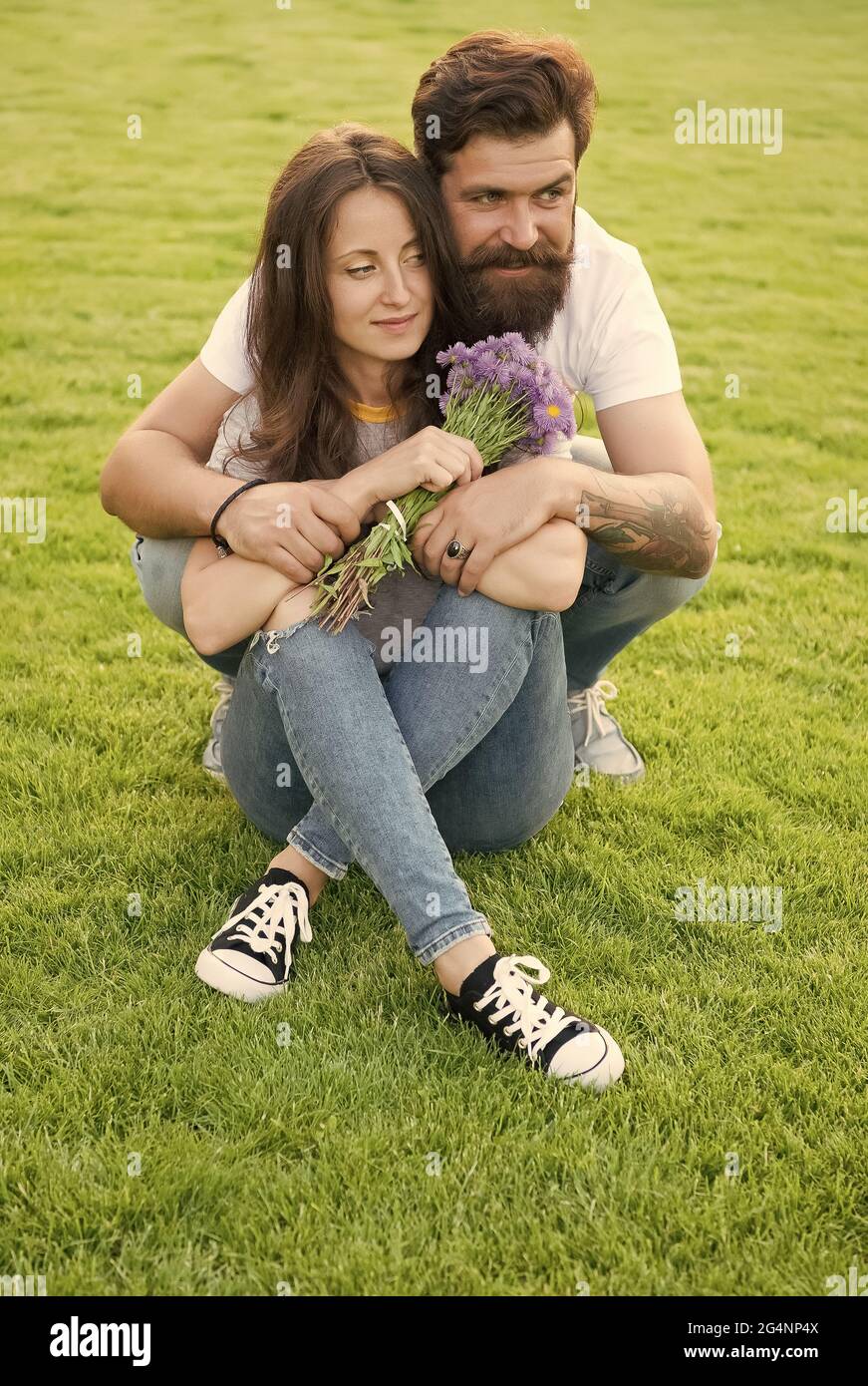 Lovely couple cuddling relaxing on green meadow, always together ...