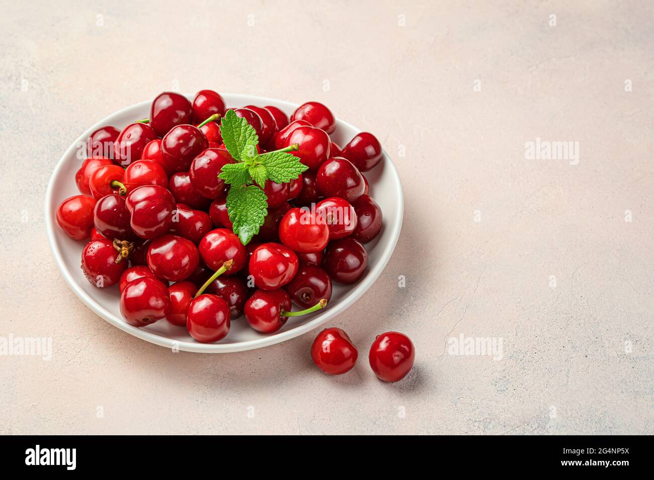 Vichy and mint in a white plate on a pink background. Side view, space ...